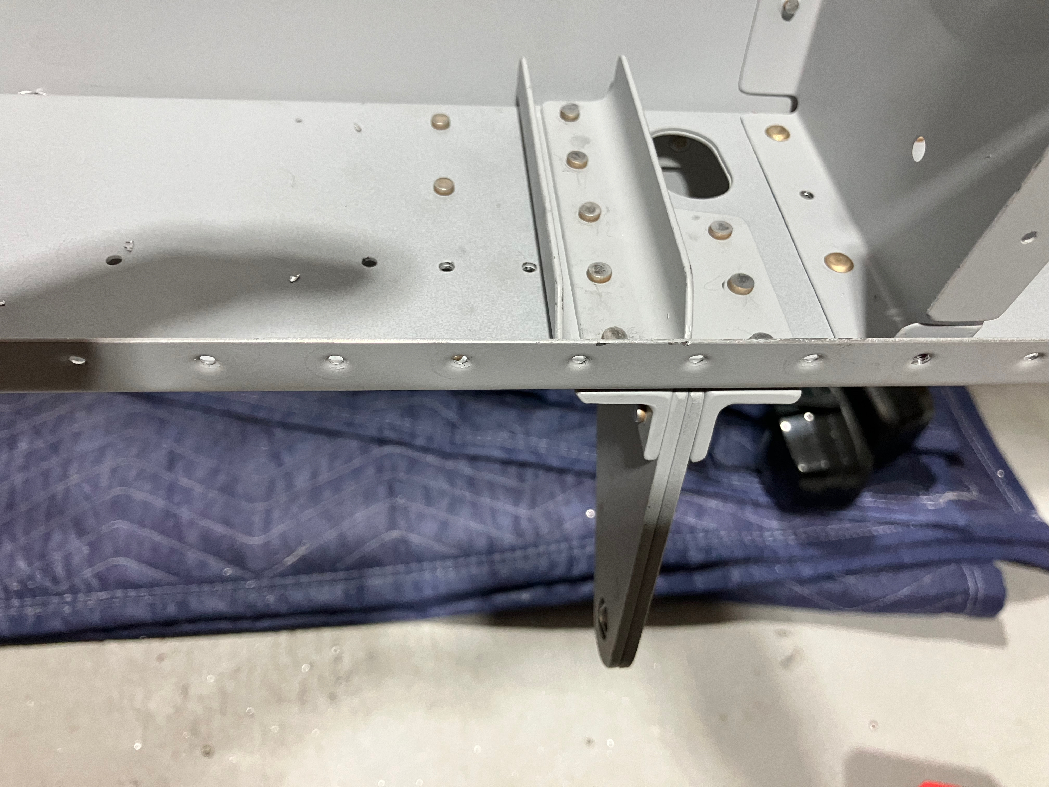 Riveting the aileron brackets.